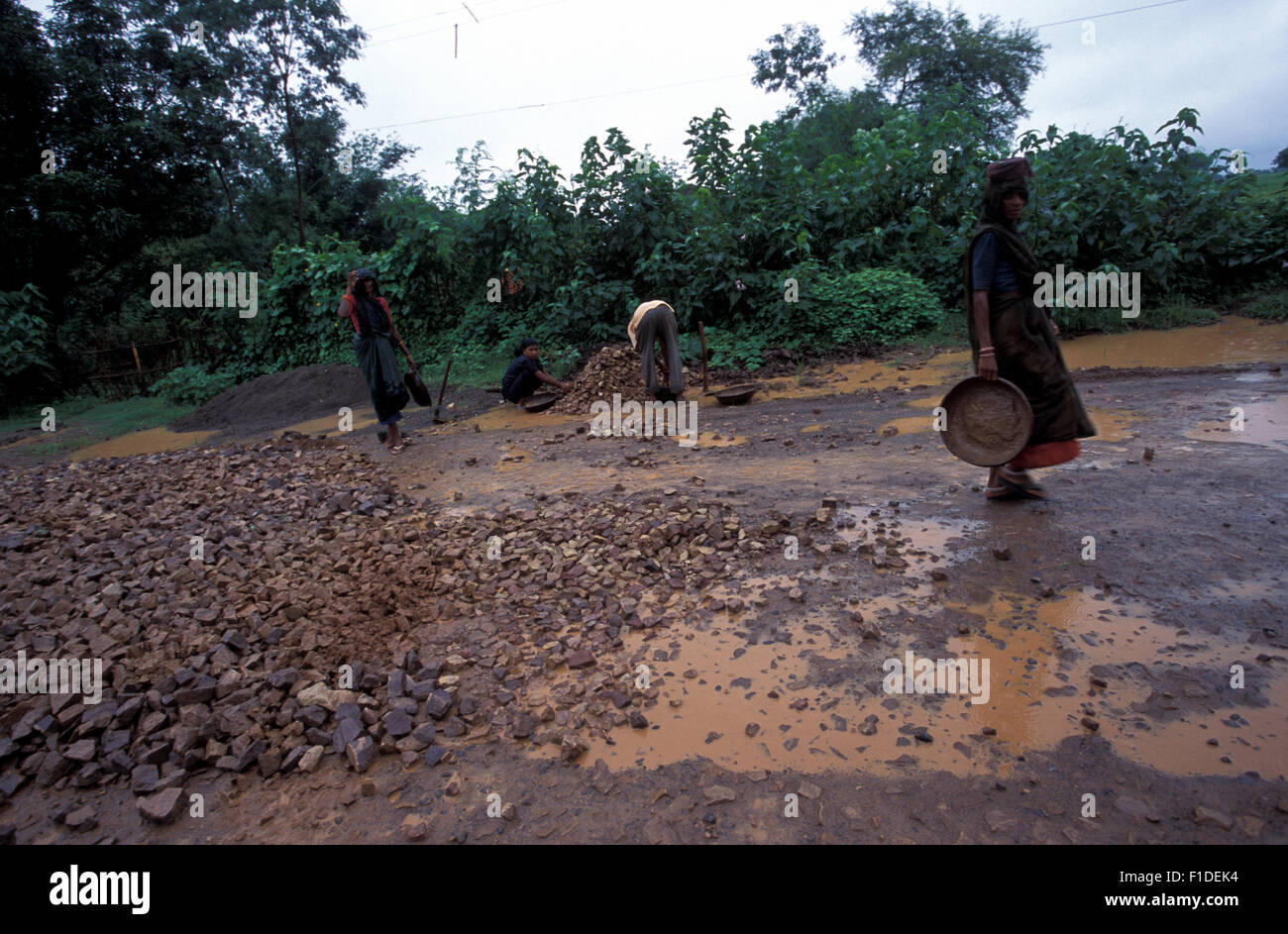 Women working repairing potholes in a india road with stones hi-res ...