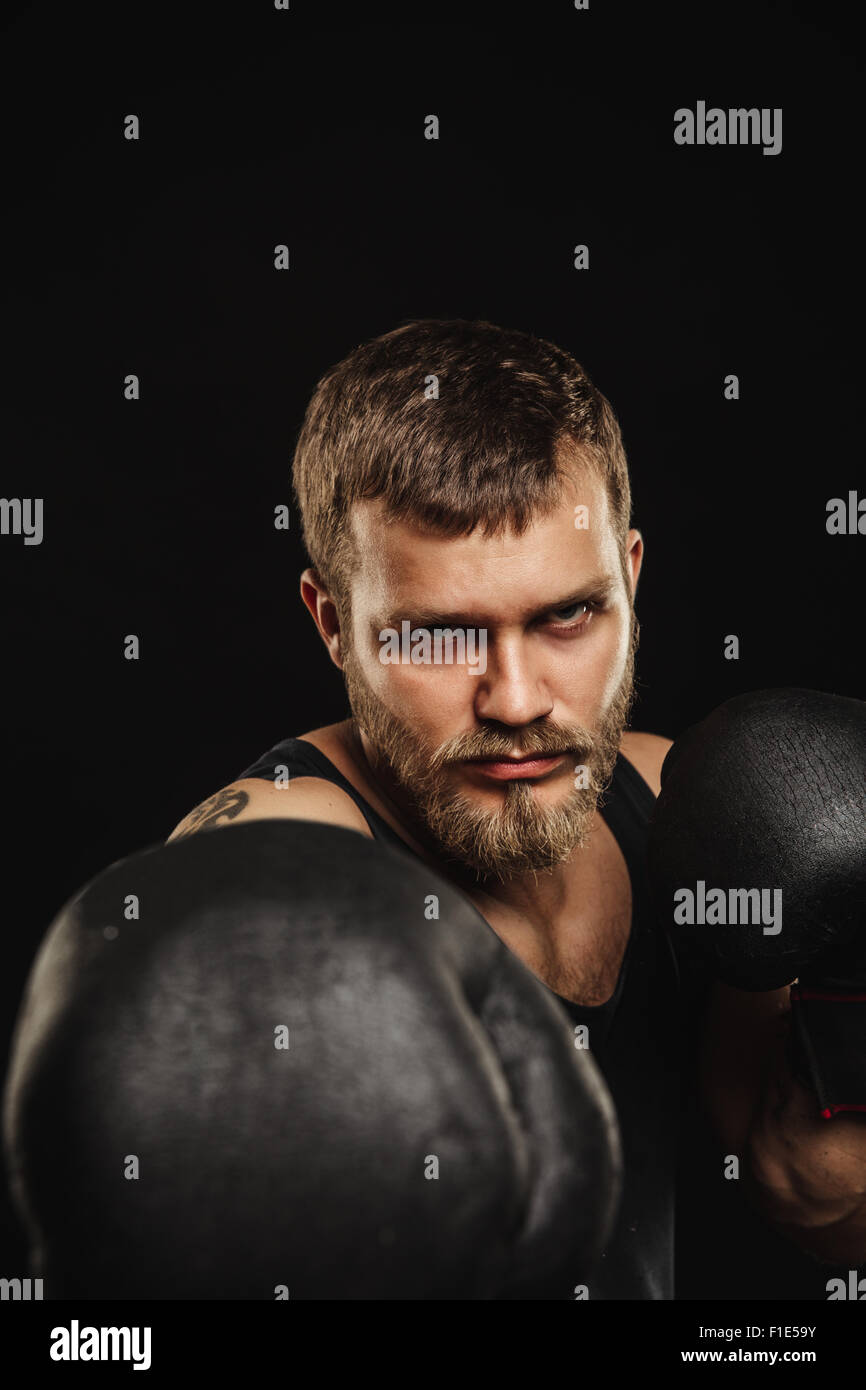 Athletic bearded boxer with gloves on a dark background Stock Photo - Alamy