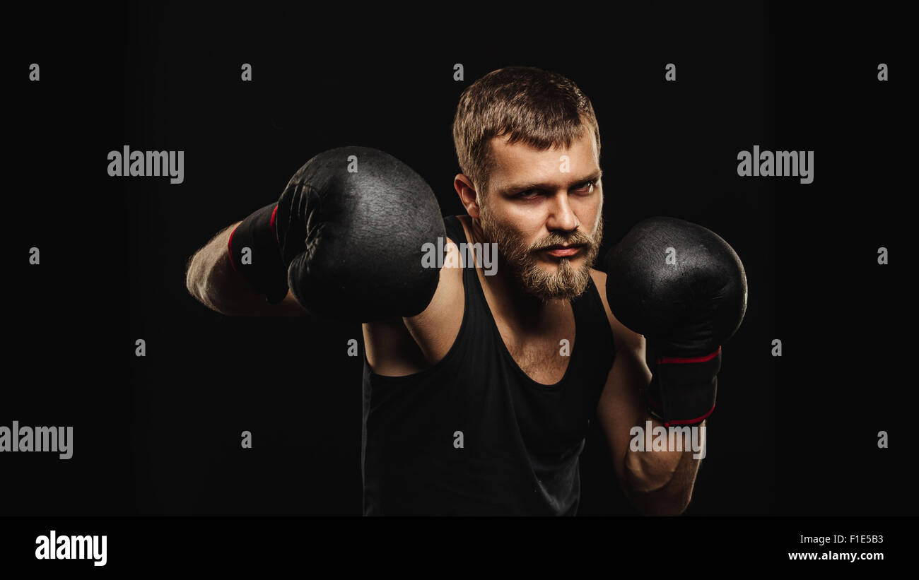 Athletic bearded boxer with gloves on a dark background Stock Photo - Alamy