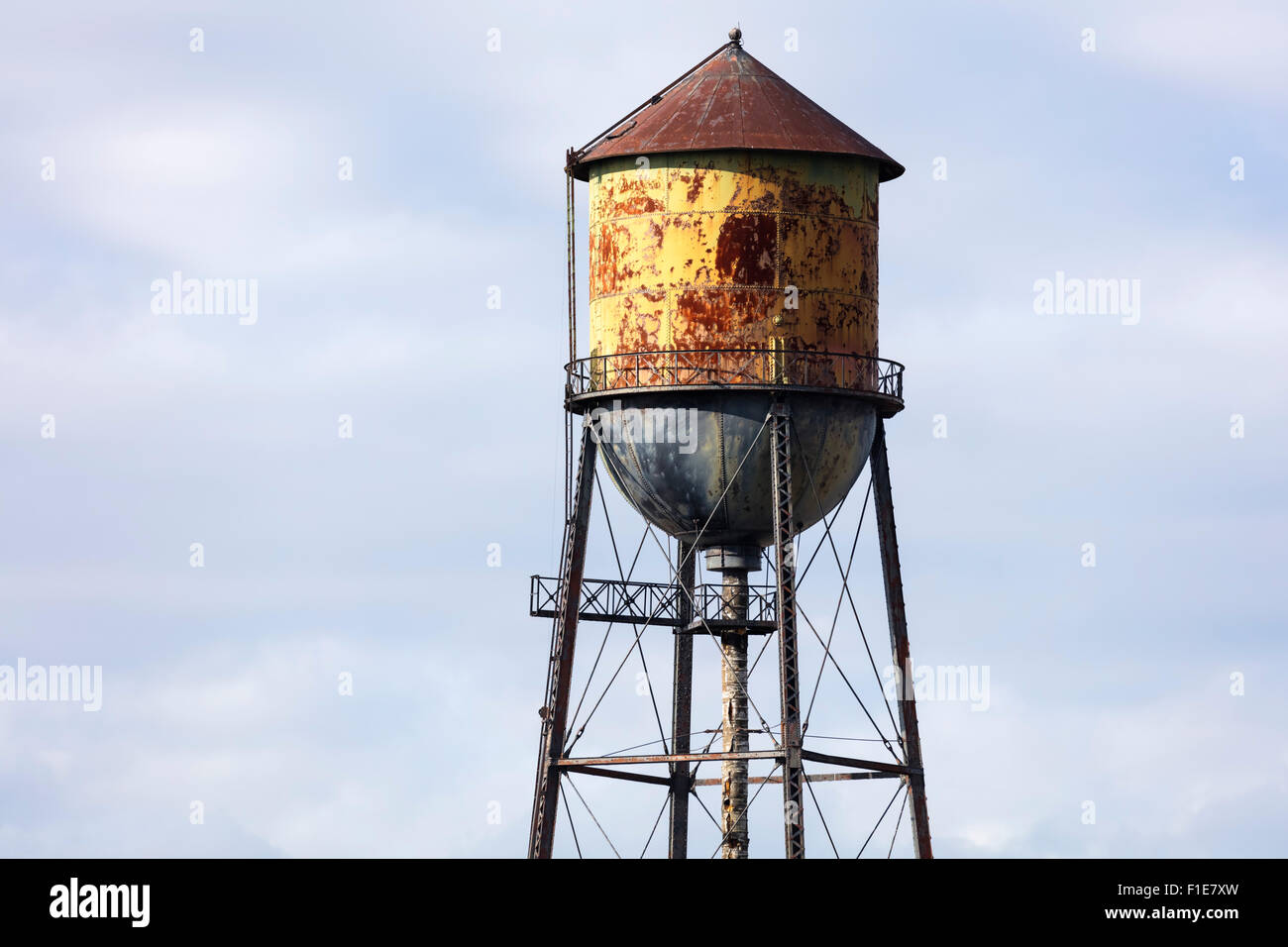 Afternoon light reveals rusty, industrial detail on an old water tower ...