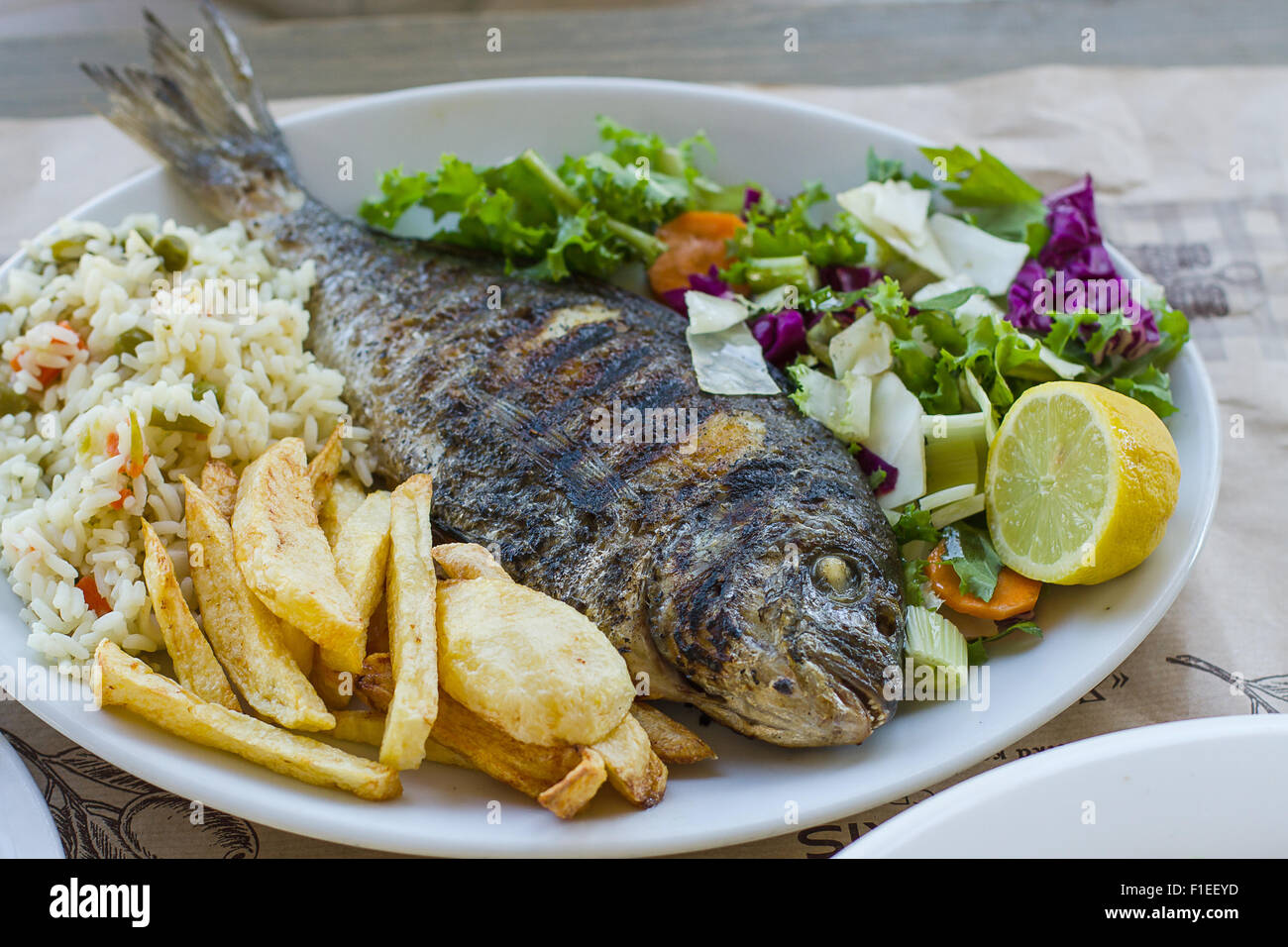 Sea bream with potato, rice and salad, top view Stock Photo - Alamy