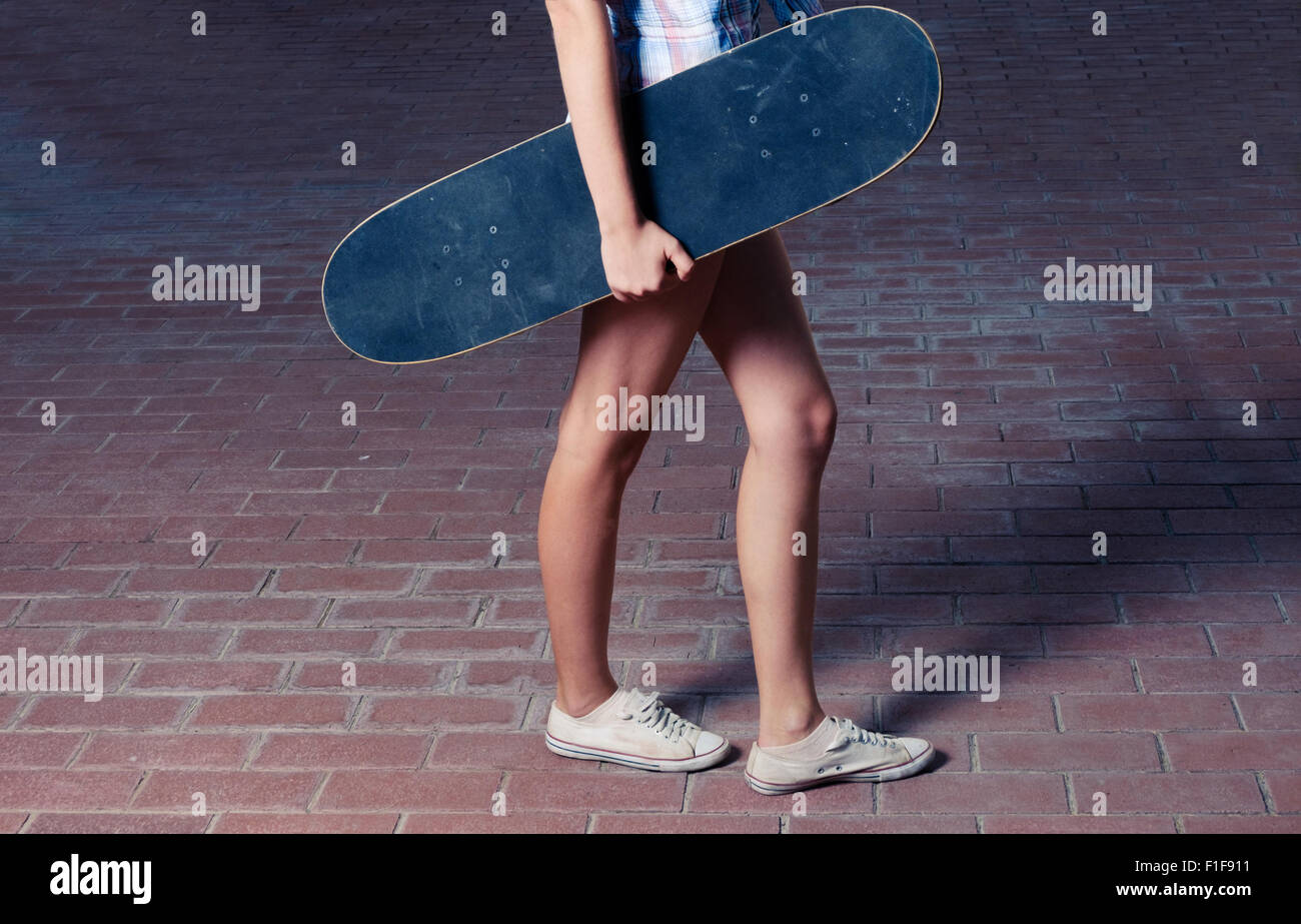 Side view of young women with skate board Stock Photo - Alamy