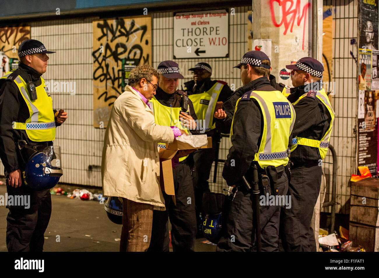London, UK. 31 August, 2015. A kind shopkeeper hands out leftover cakes ...