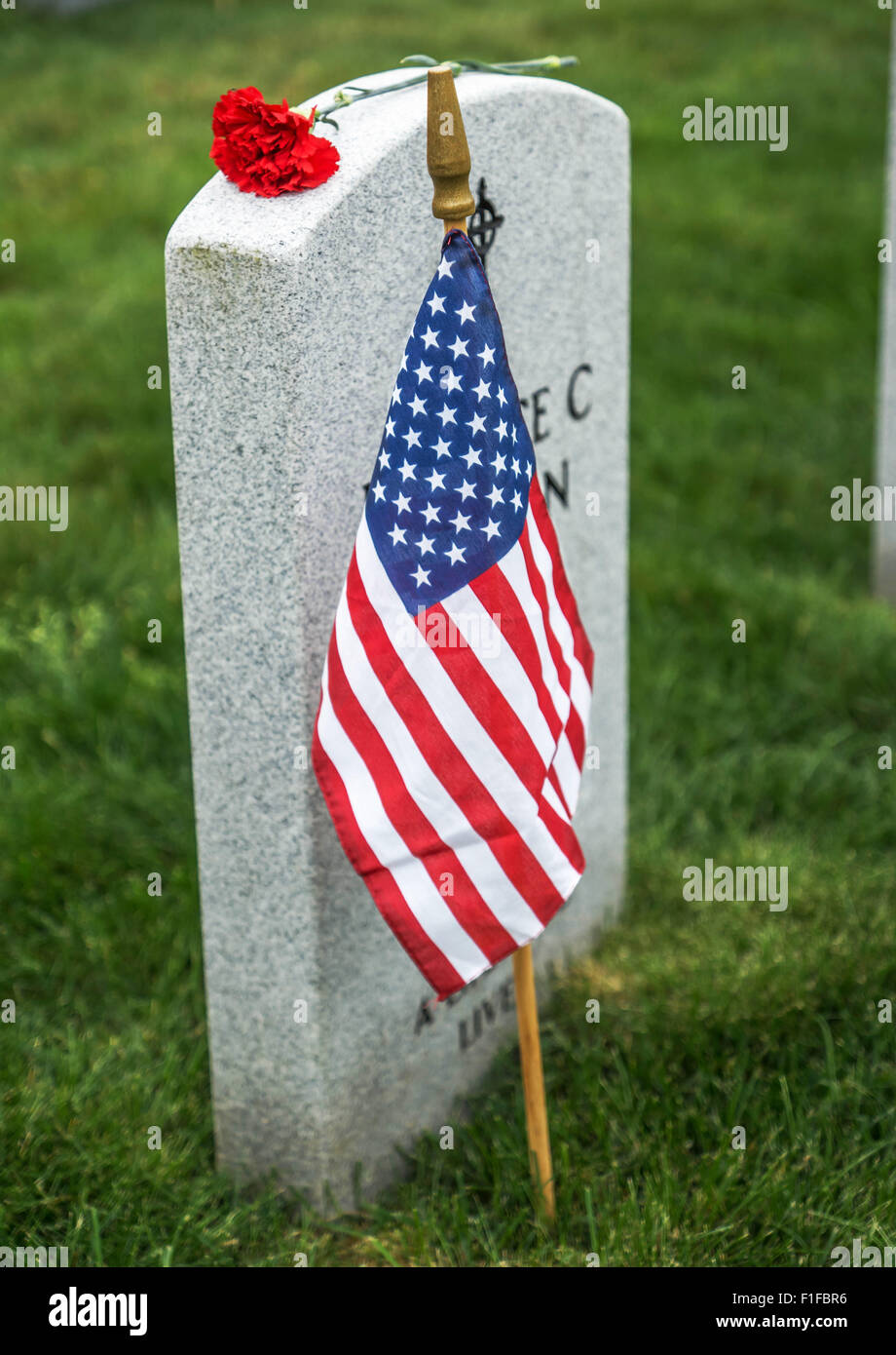 American flag and Red Rose on a veterans tombstone at an American ...