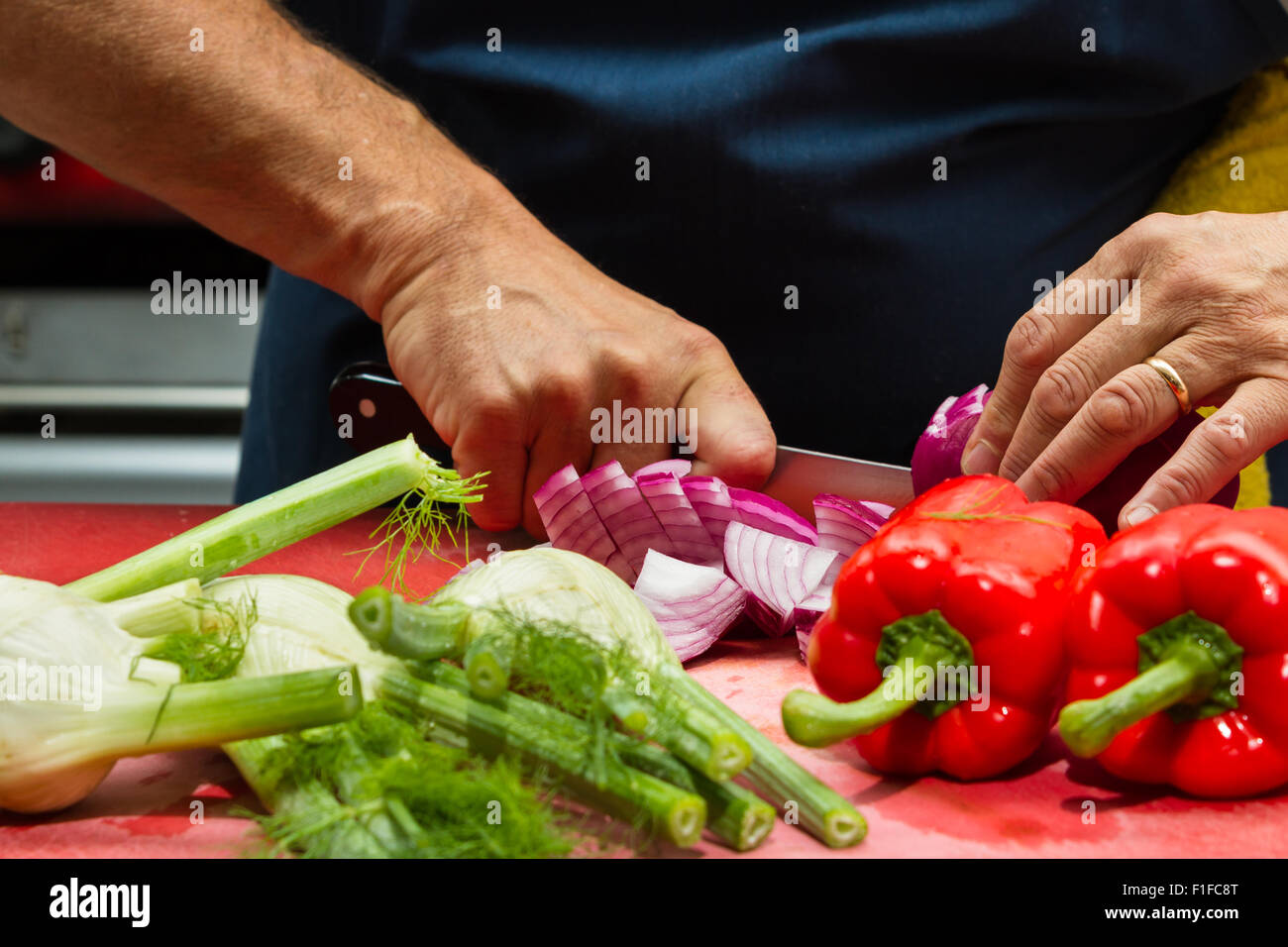 close up of a chef's hands slicing fresh vegetables in a restaurant ...
