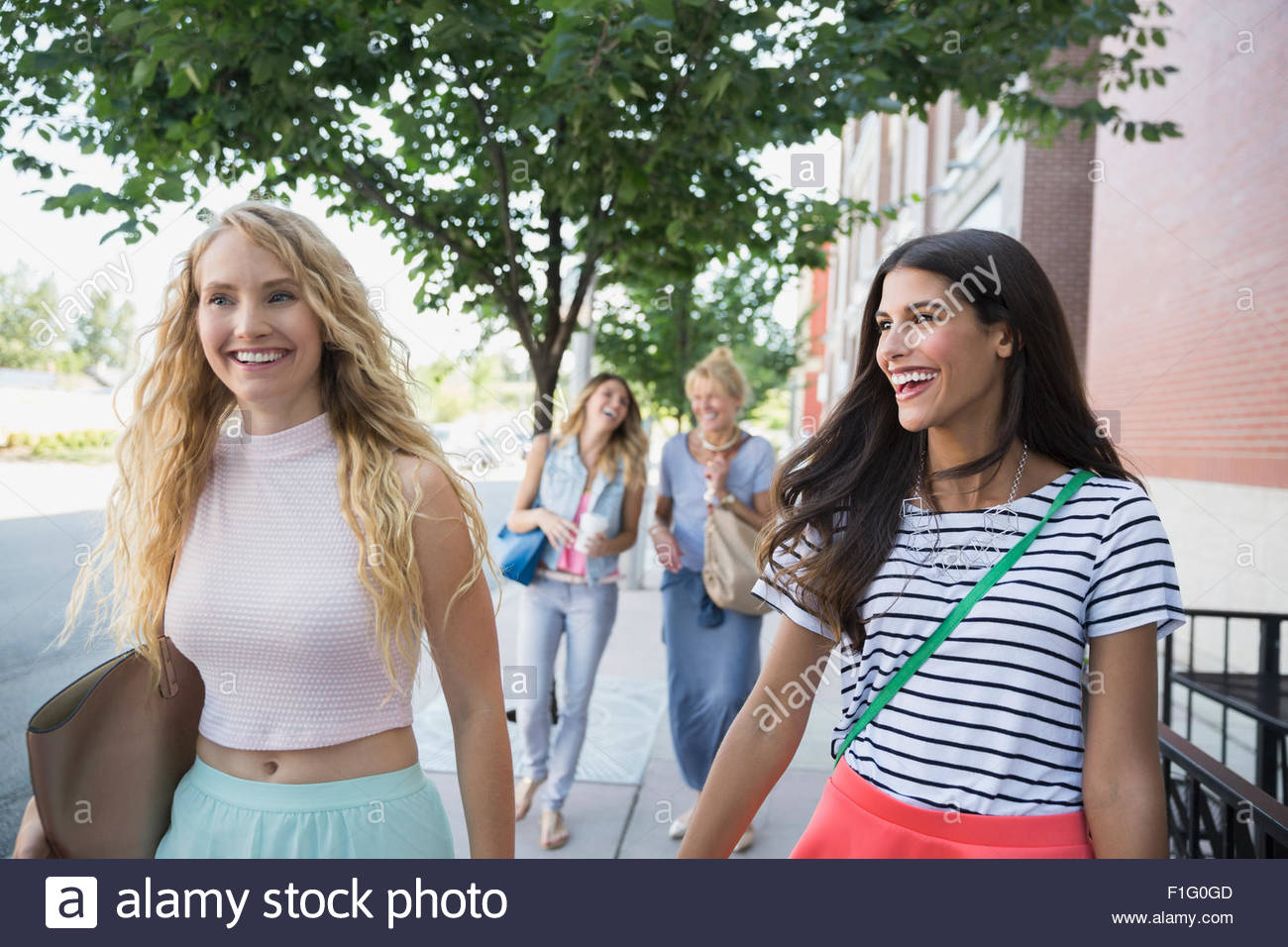 Three women walking sidewalk hi-res stock photography and images - Alamy