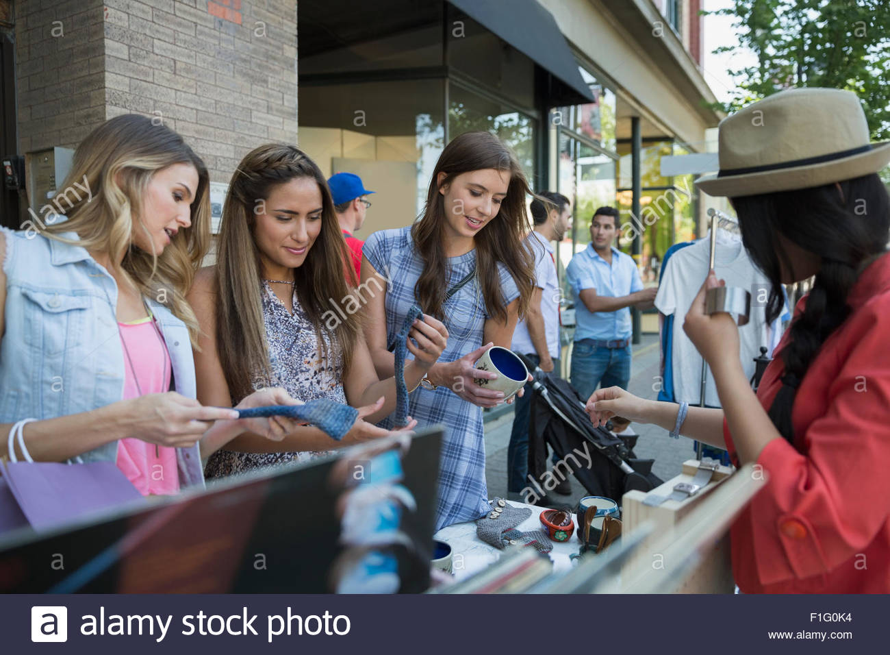 Women browsing merchandise at sidewalk sale Stock Photo - Alamy