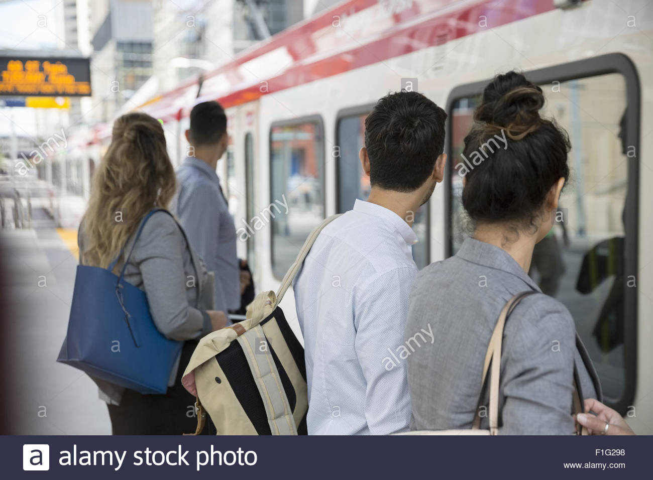 Business people waiting to board train on platform Stock Photo - Alamy