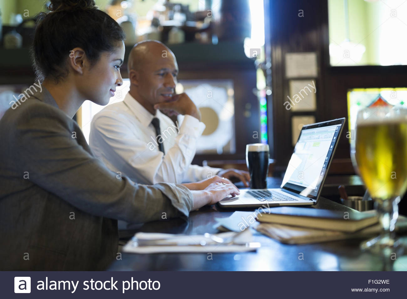 Business people working at laptop in pub Stock Photo - Alamy