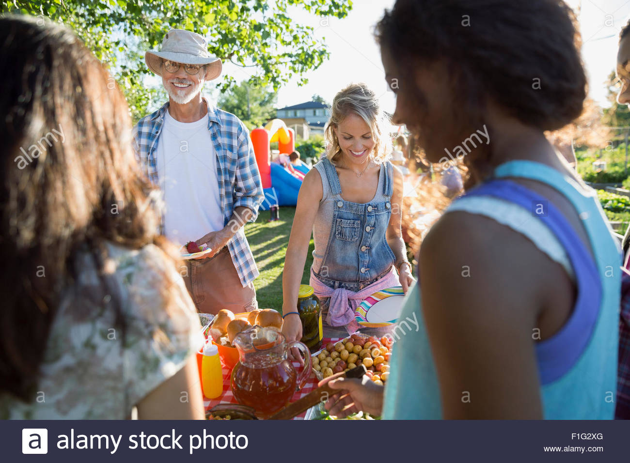 Neighbors around potluck table in park Stock Photo - Alamy