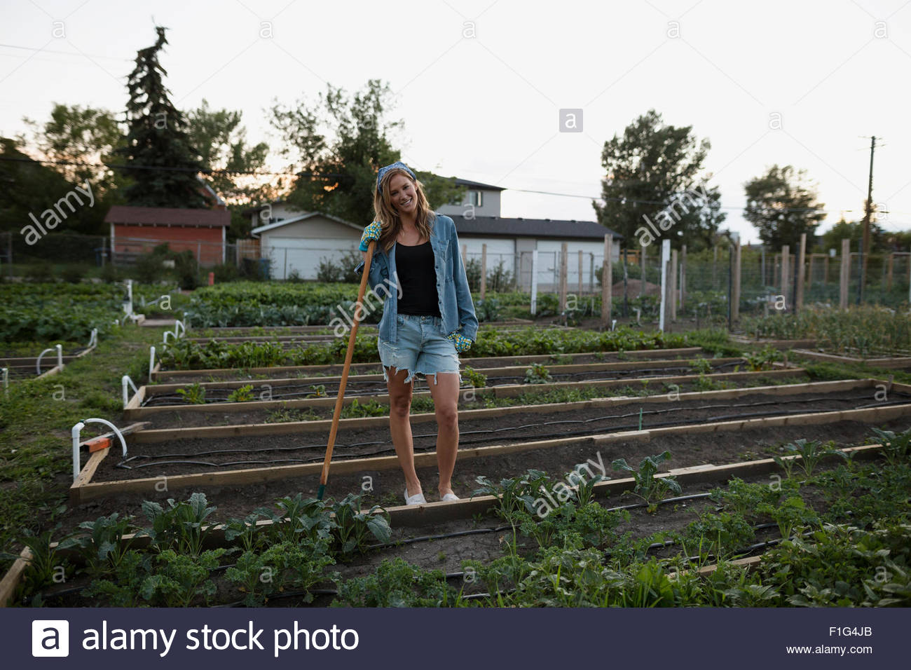 Portrait smiling woman tending to vegetable garden Stock Photo - Alamy