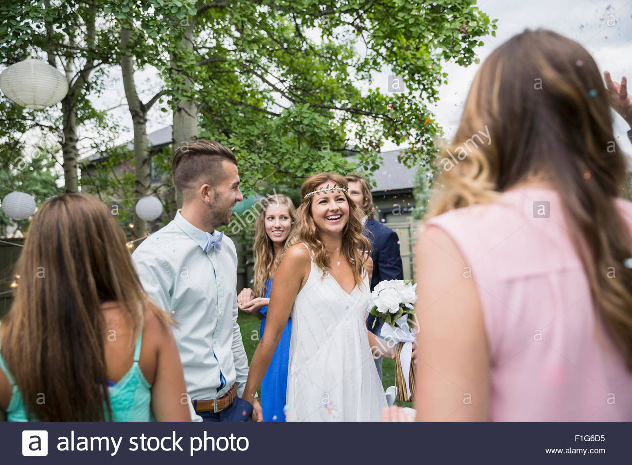Bride and groom surrounded by friends backyard wedding Stock Photo - Alamy
