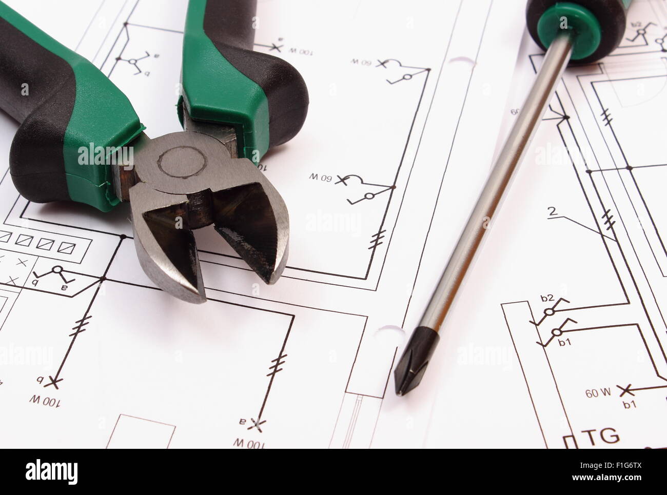 Metal pliers and screwdriver on electrical construction drawing of ...