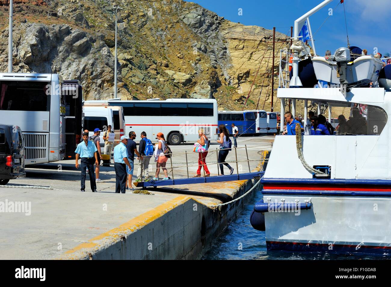 Passengers walking down the ramp of a ferry in the port of Ormos ...