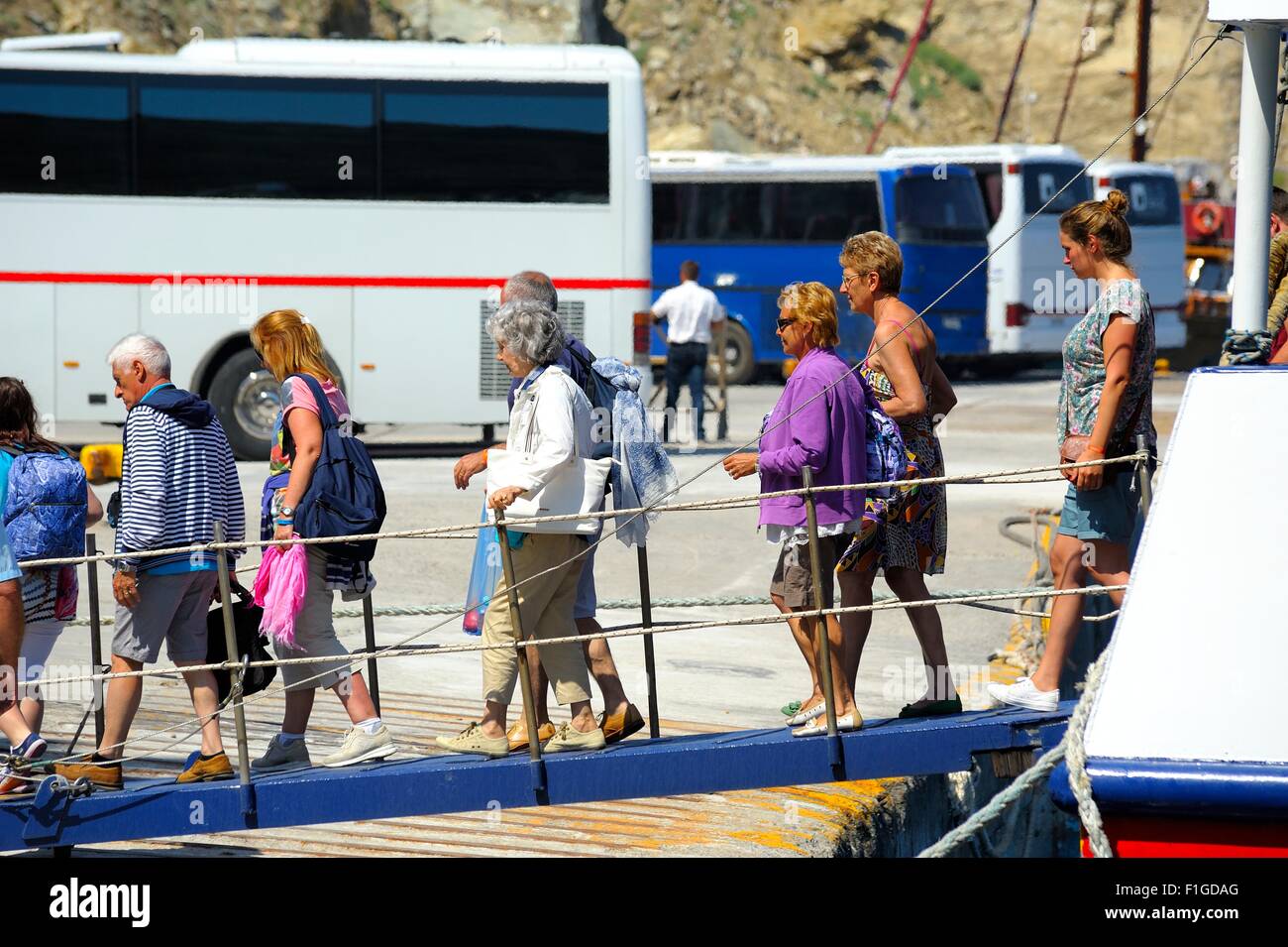 Passengers walking down the ramp of a ferry in the port of Ormos ...