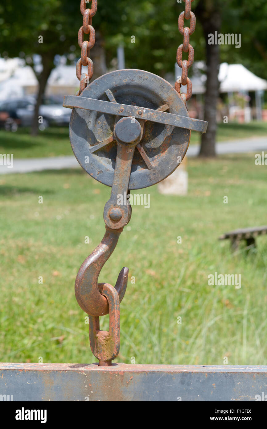 Rusty hook with gear, pulleys and chain on crane for lifting heavy ...