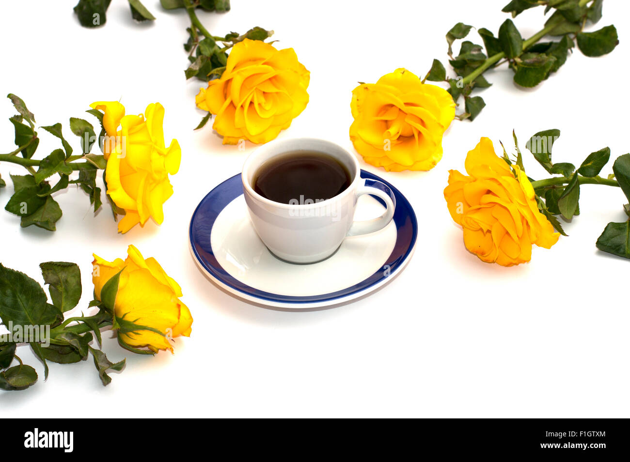 five yellow roses round a cup of coffee Stock Photo - Alamy