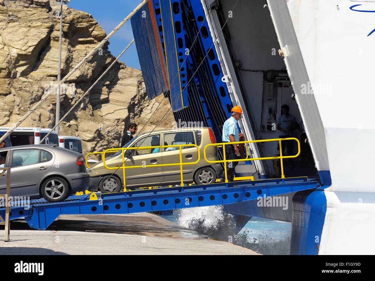 Passengers walking down the ramp of a ferry in the port of Ormos ...