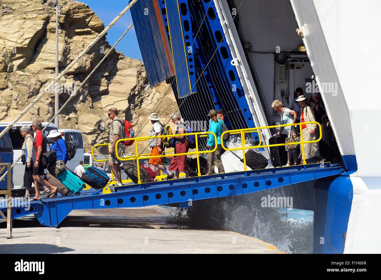 Passengers walking down the ramp of a ferry in the port of Ormos ...