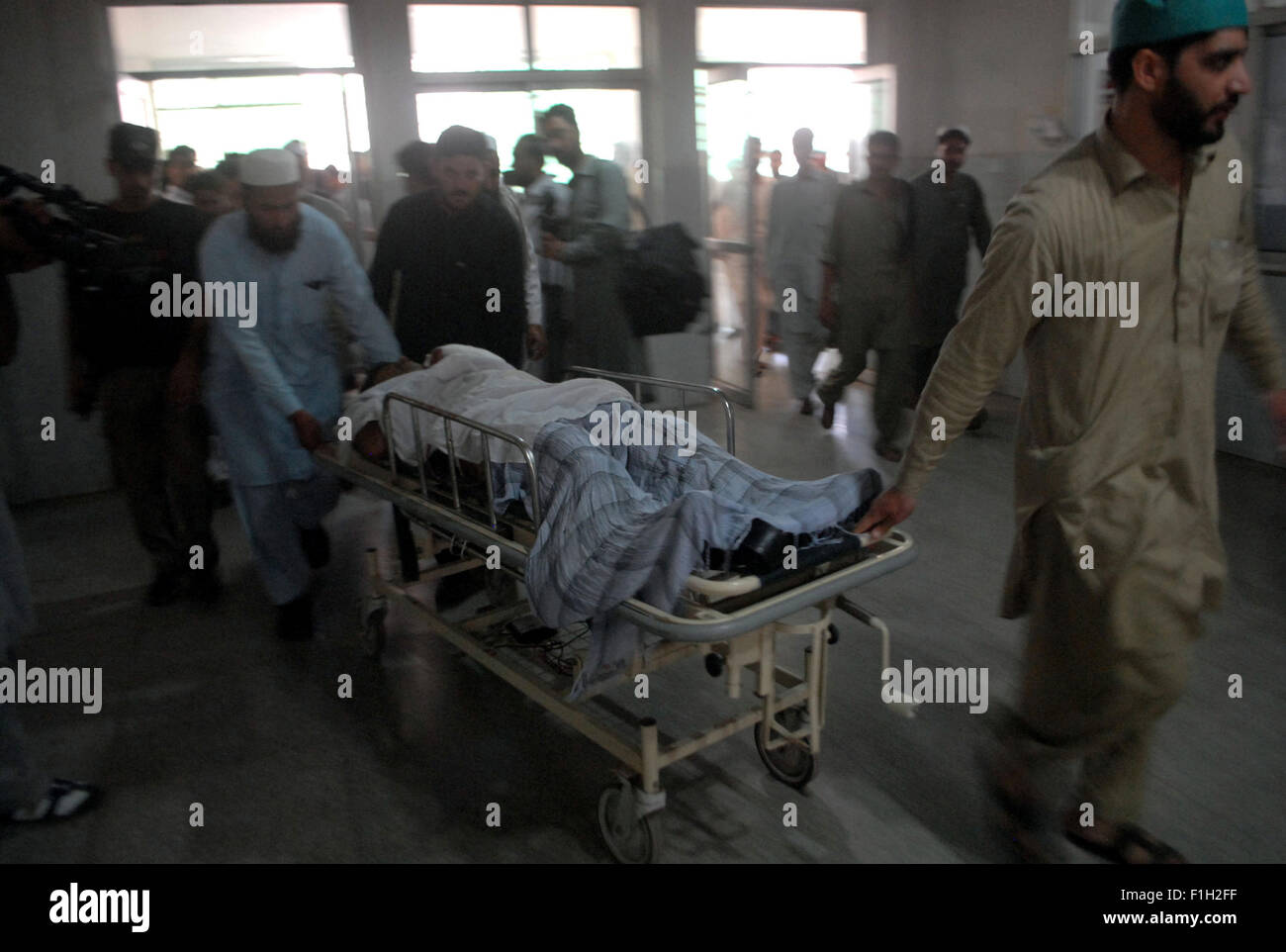 Peshawar. 2nd Sep, 2015. People transfer an injured policeman to a ...