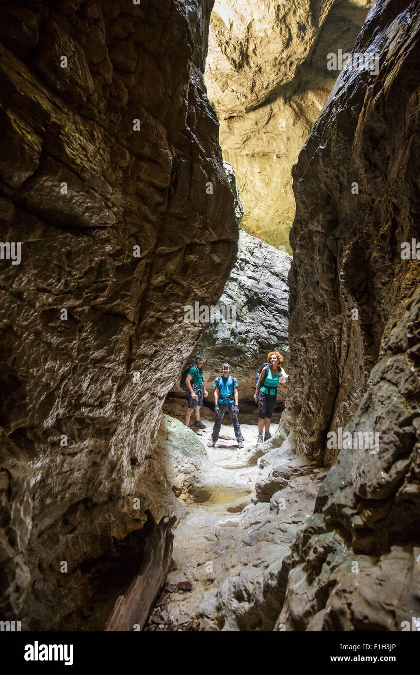 Family of tourists standing in a huge cave, Cetatile Radesei, Romania ...