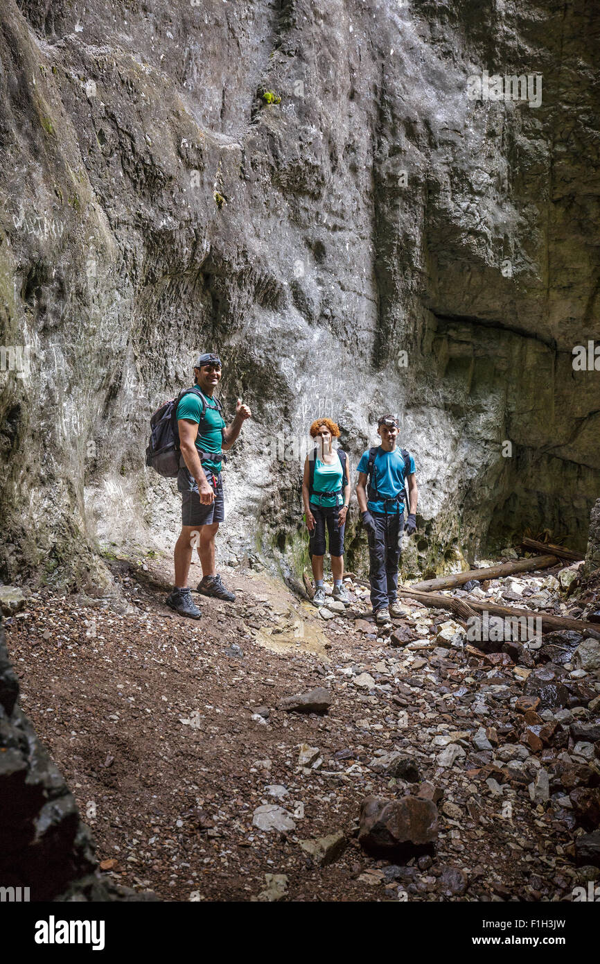 Family of tourists standing in a huge cave, Cetatile Radesei, Romania ...