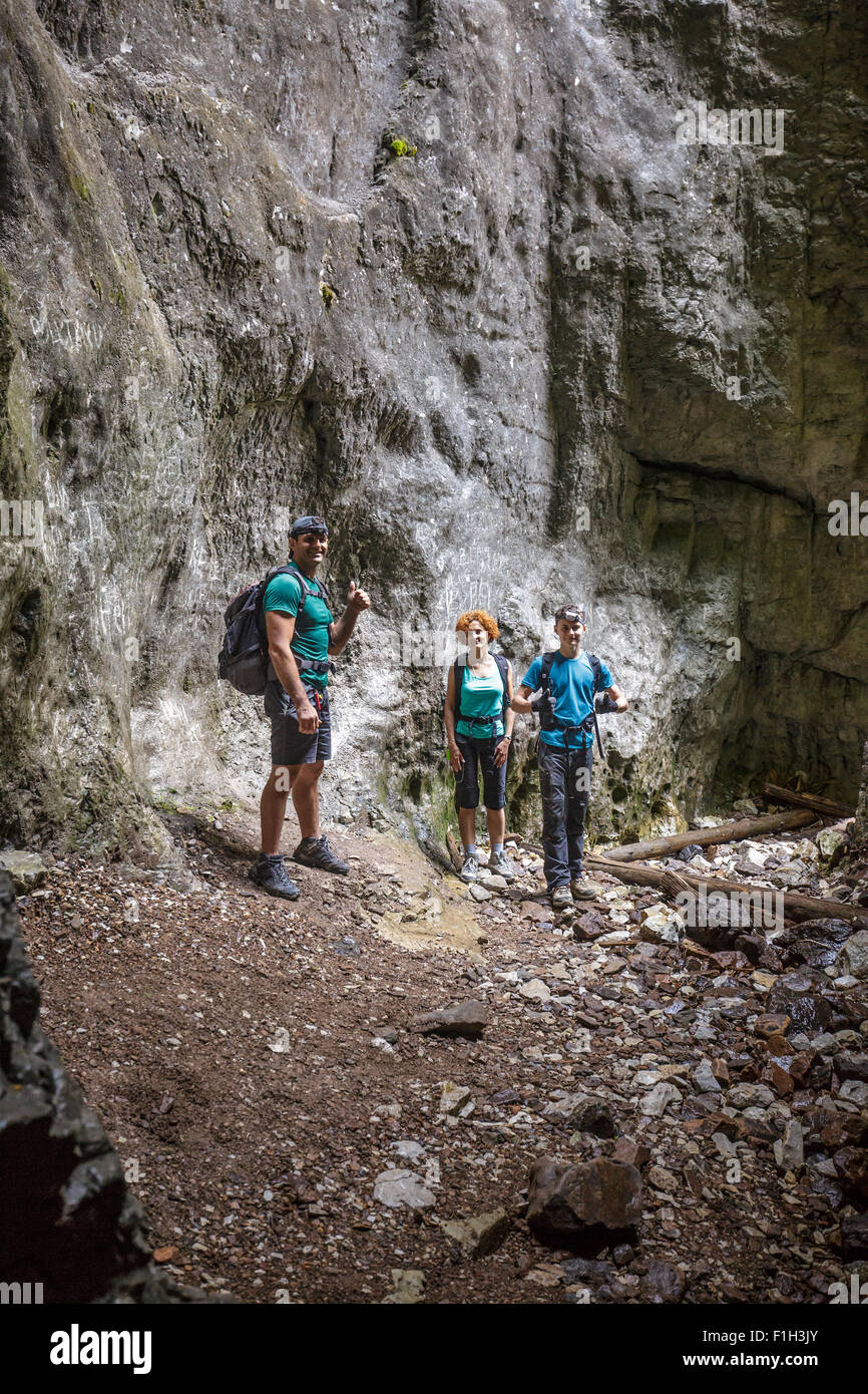 Family of tourists standing in a huge cave, Cetatile Radesei, Romania ...