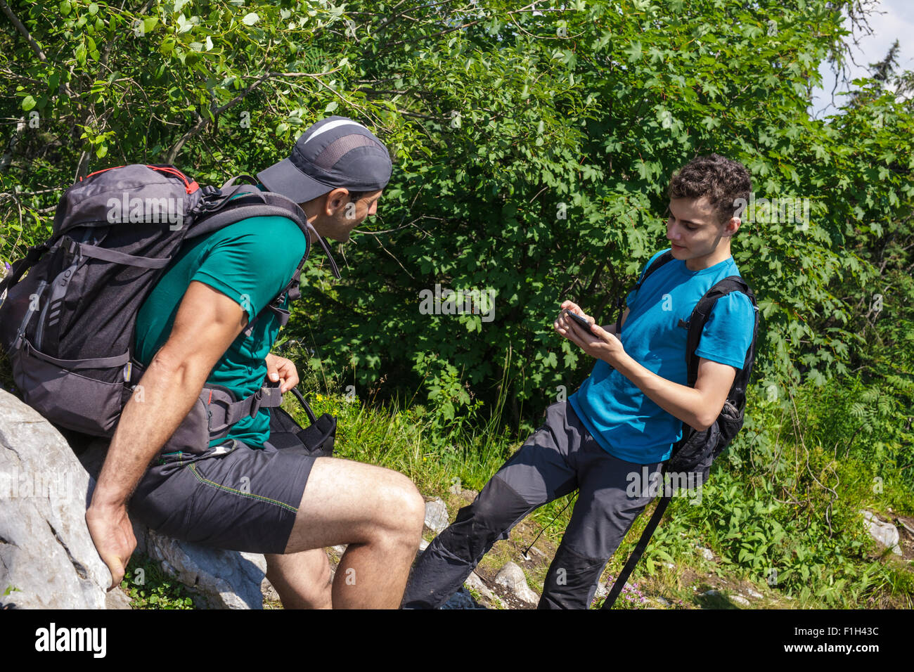 Male hikers taking a brake on mountain trail Stock Photo - Alamy