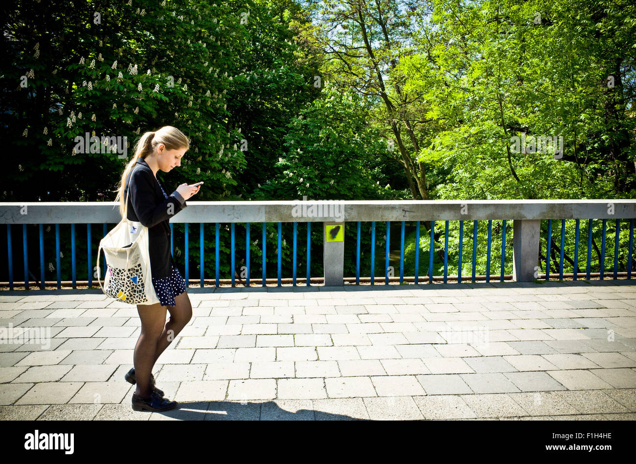 girl walking and looking at her smartphone Stock Photo - Alamy