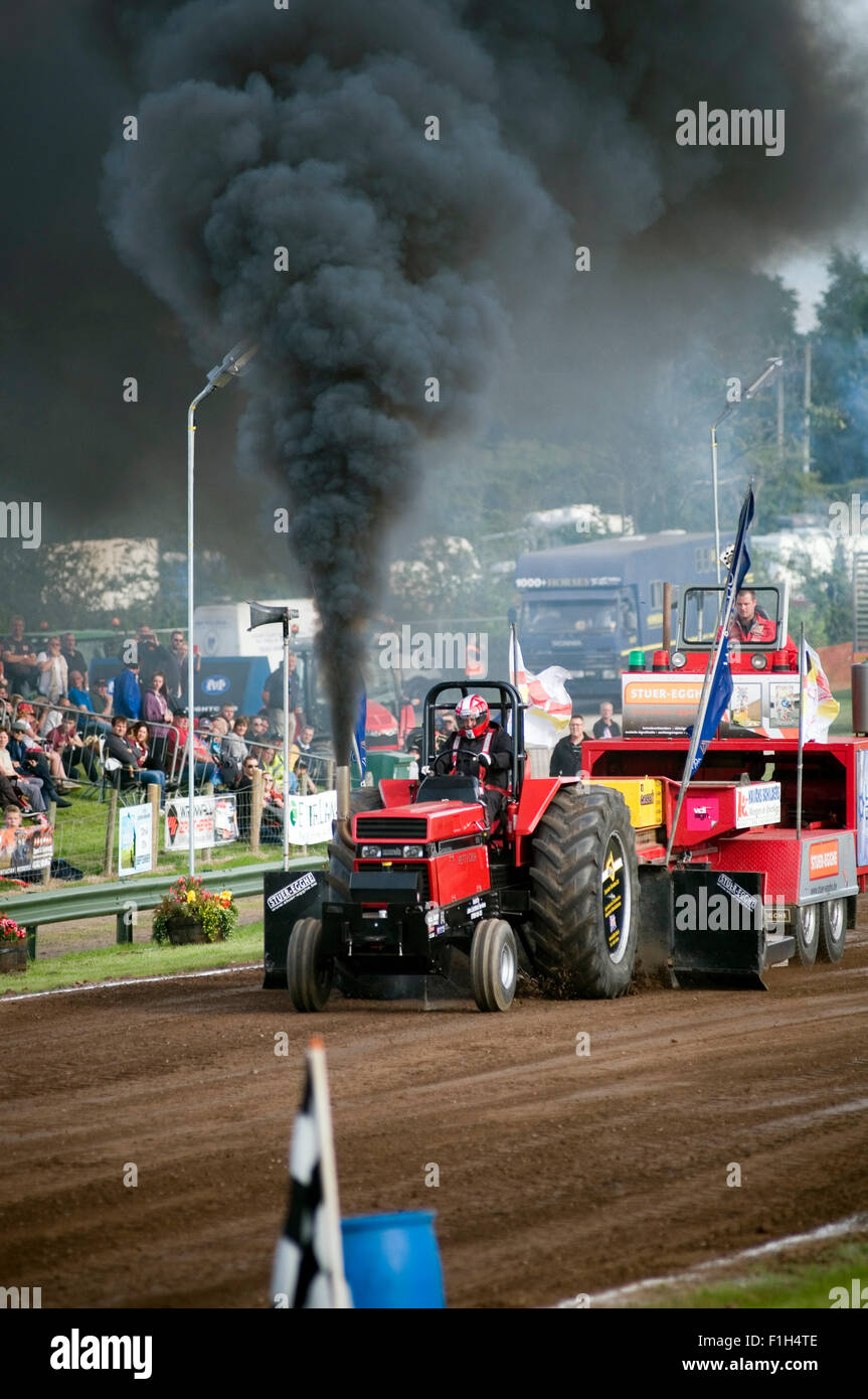 tractor puller competing in a tractor pull producing a huge cloud of ...