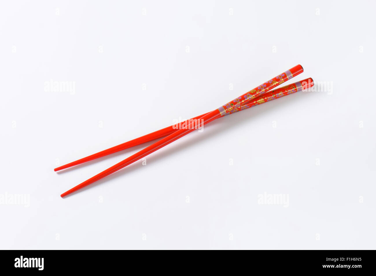 pair of red chopsticks on white background Stock Photo - Alamy