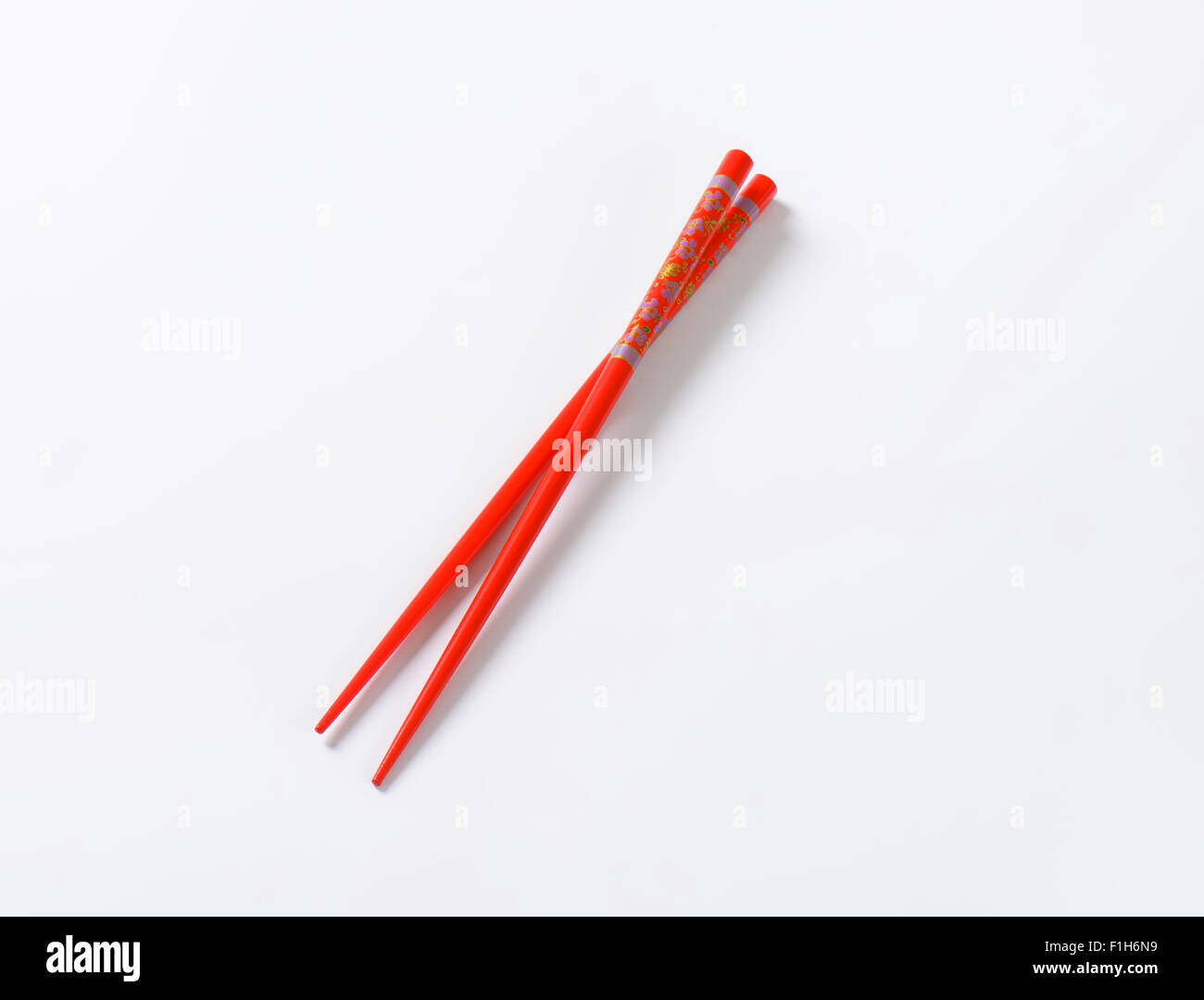 pair of red chopsticks on white background Stock Photo - Alamy
