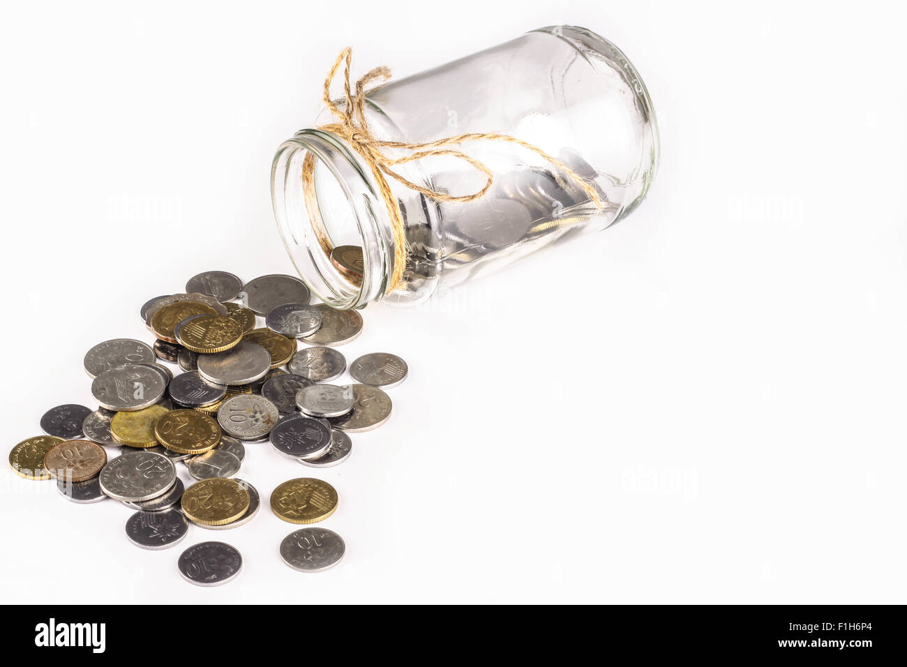 coins outside the glass jar isolated on white background. close-up ...