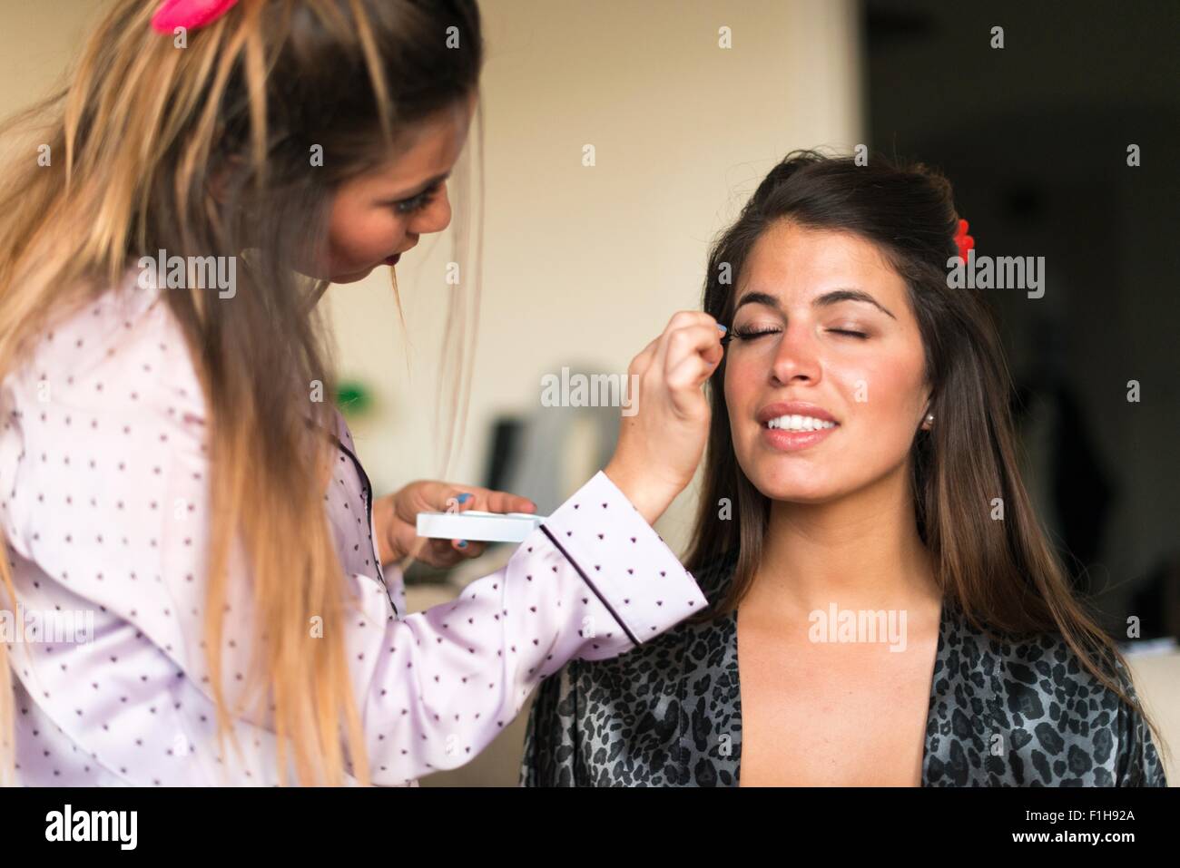 Two young women, applying make-up Stock Photo - Alamy