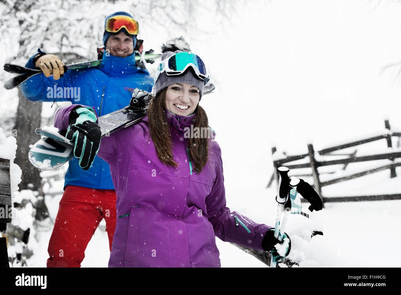 Man and woman carrying skis Stock Photo - Alamy