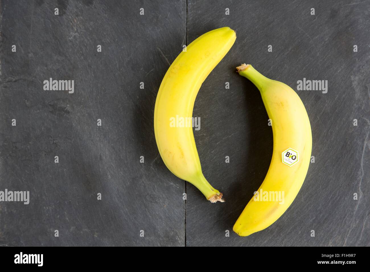Still life of two bananas - one with bio label Stock Photo - Alamy