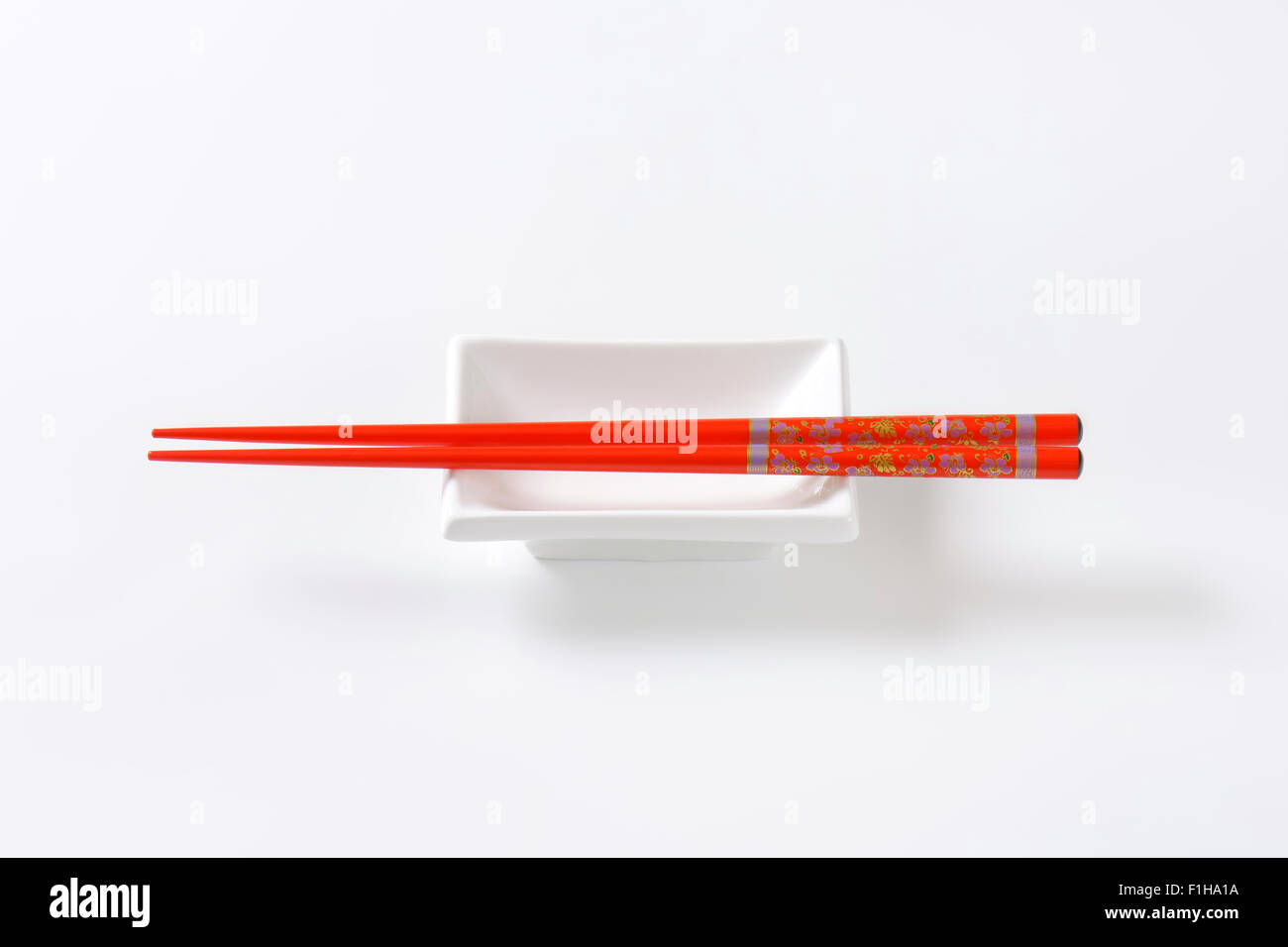 pair of red chopsticks and white bowl on white background Stock Photo ...