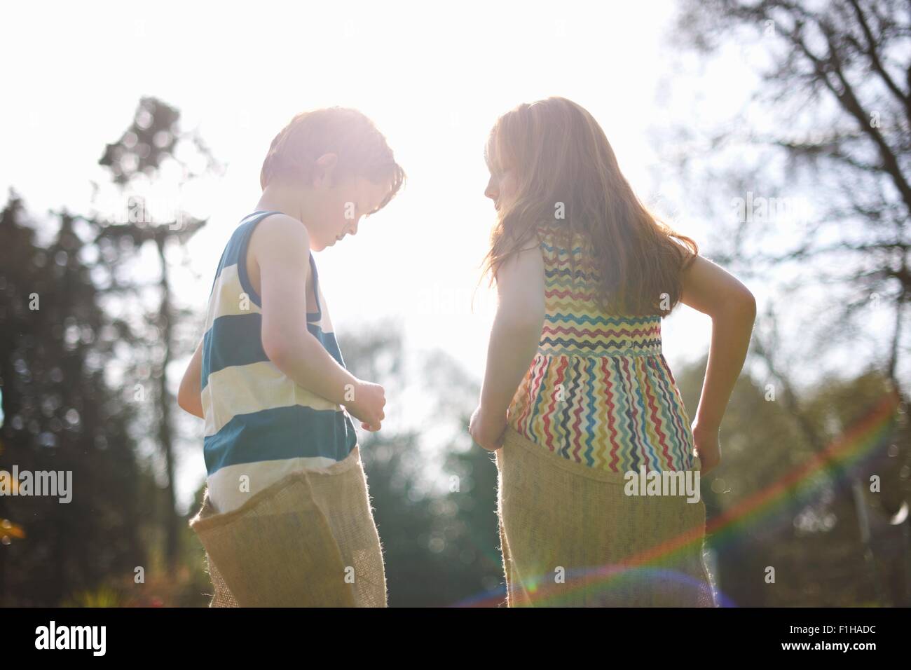 Two young children having sack race Stock Photo - Alamy