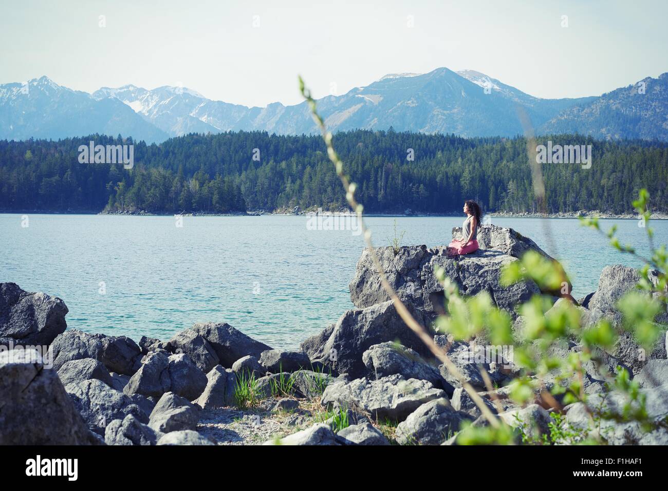 Mid adult woman, sitting on rock, in yoga position Stock Photo - Alamy