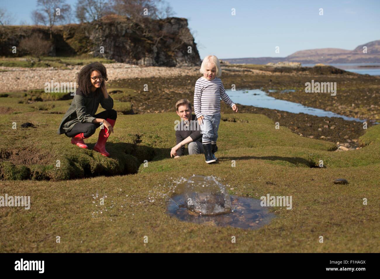 Boy throwing rock into puddle, Isle of Skye, Hebrides, Scotland Stock ...