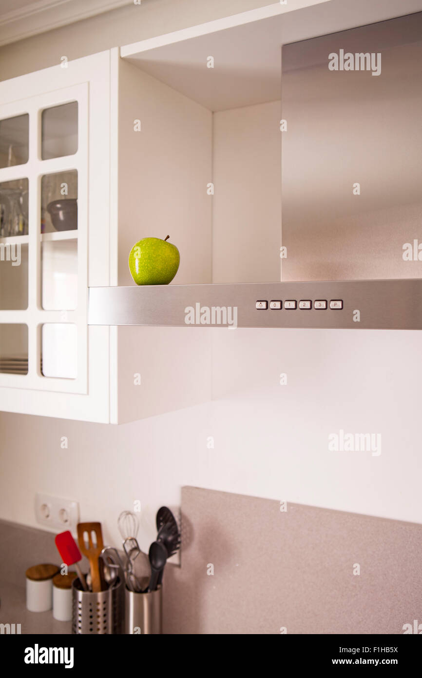 Green apple symbolizing cleanliness in a modern white kitchen with ...