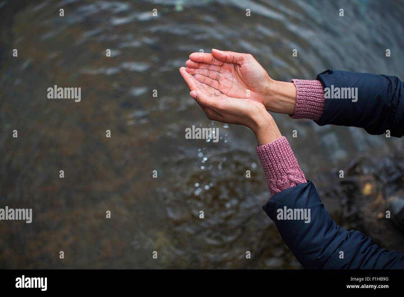 Woman holding water in cupped hands Stock Photo - Alamy