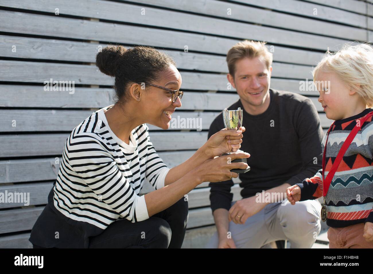 Mother giving son trophy Stock Photo - Alamy