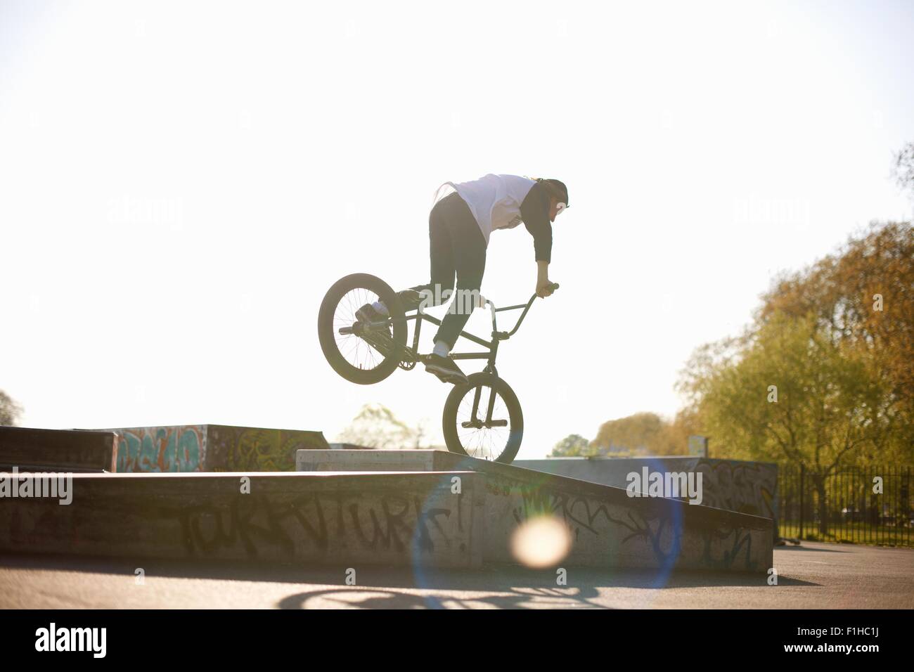 Young man doing stunt on bmx at skatepark, rear view Stock Photo - Alamy