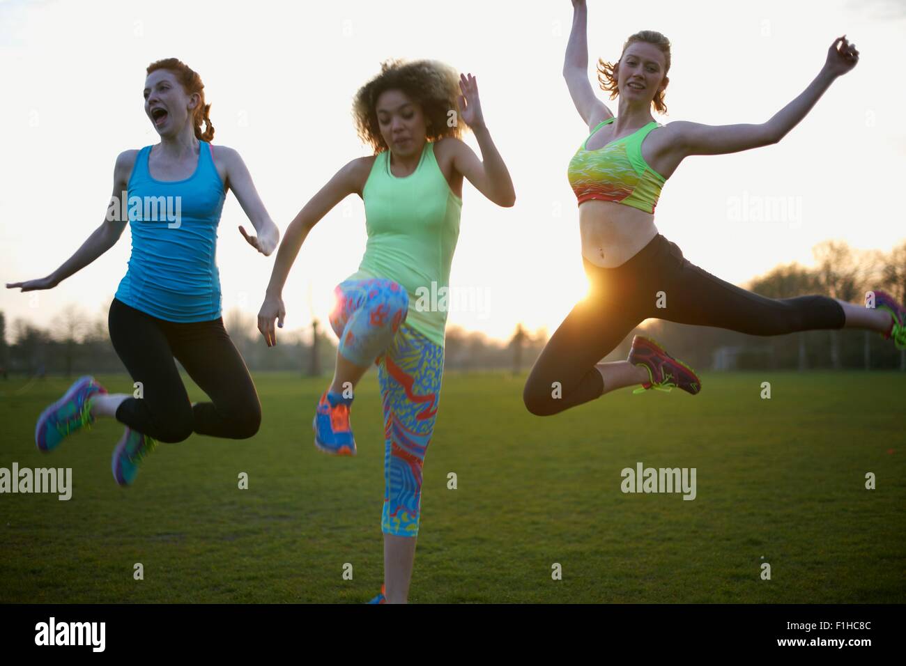 Portrait of three women jumping in the park Stock Photo - Alamy