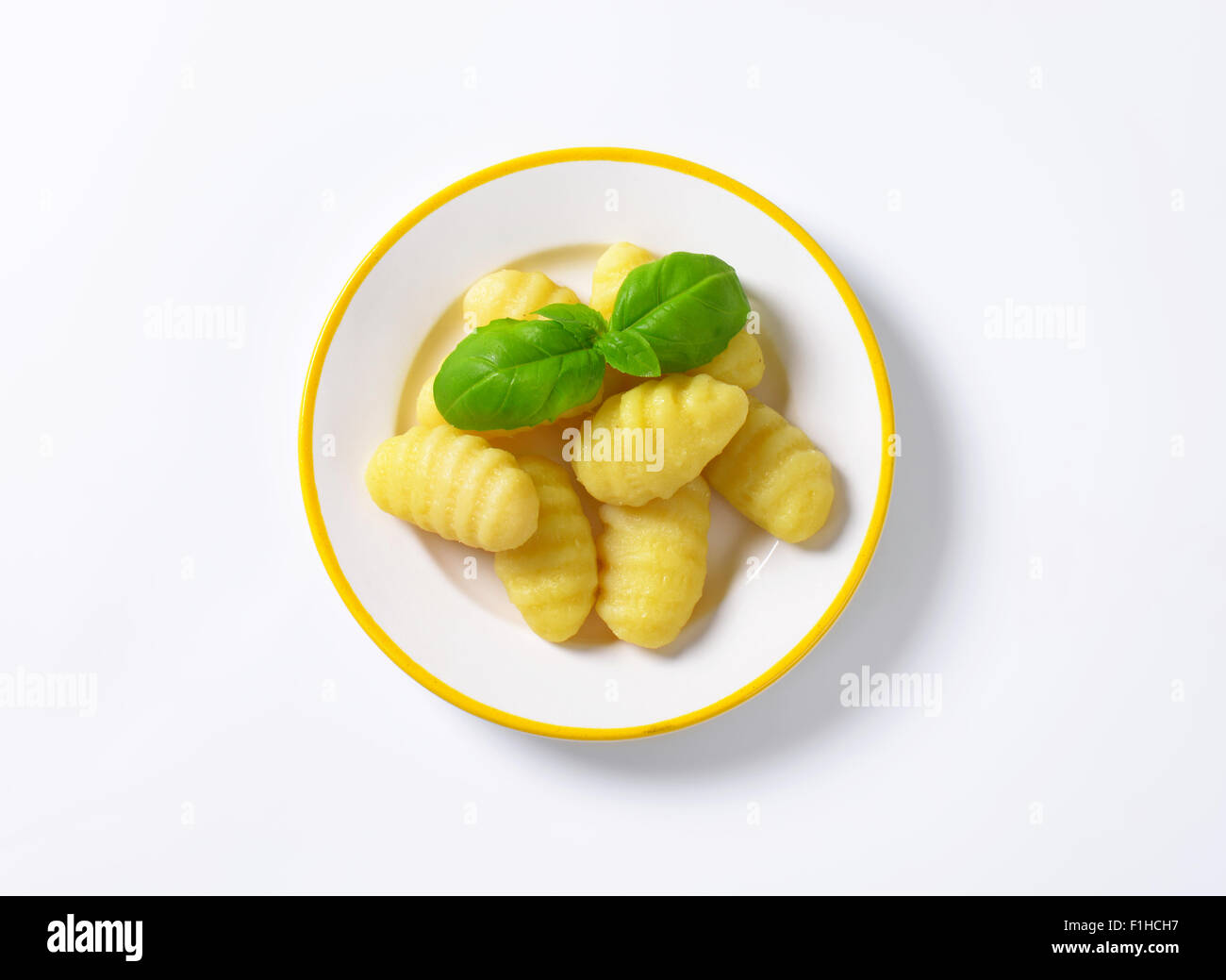 plate of cooked gnocchi on white background Stock Photo - Alamy