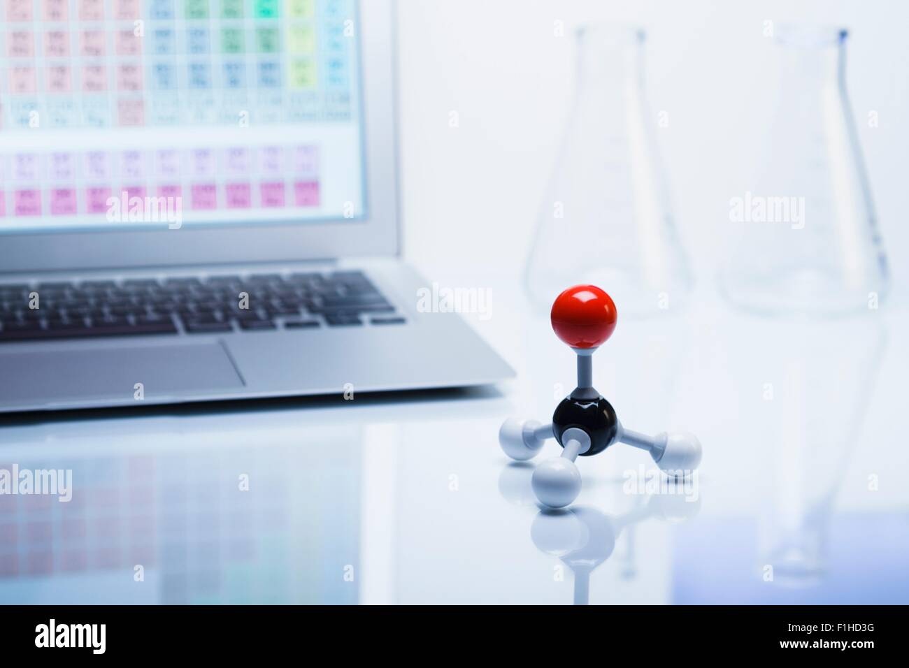 Chemistry research. Ball-and-stick molecular model with laptop computer ...