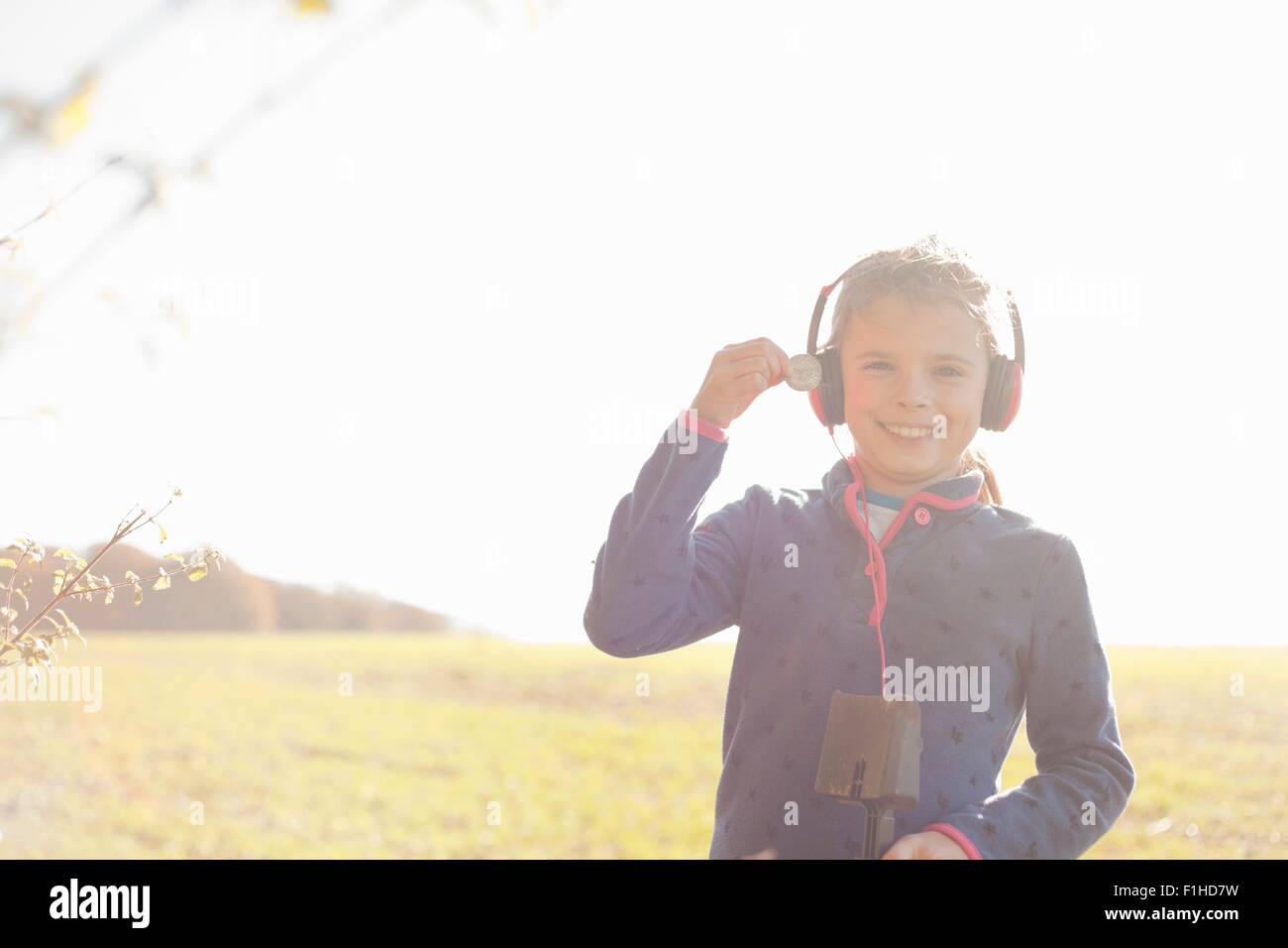 Portrait of girl metal detecting in field holding up silver coin Stock ...