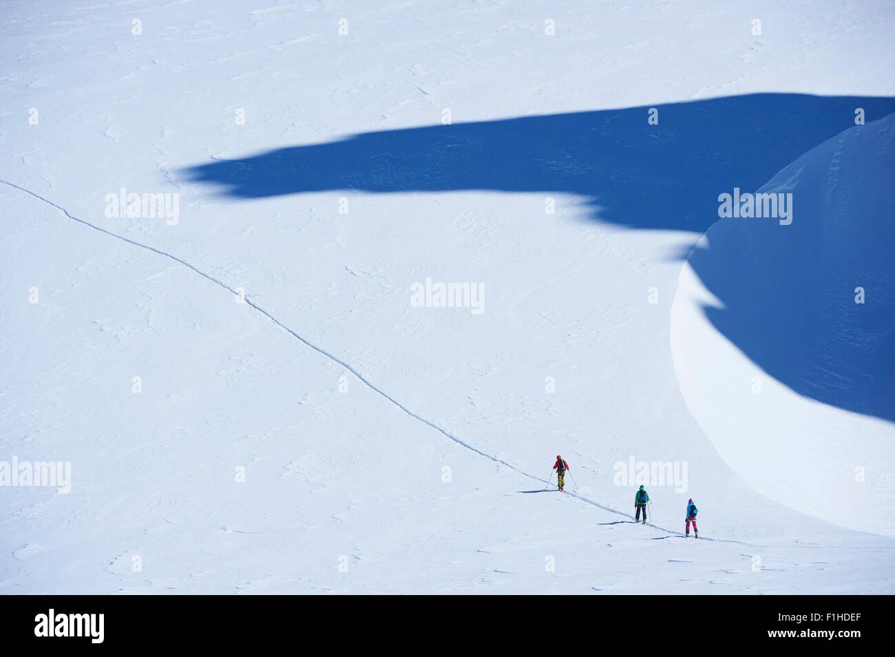 Distant view of three skiers on track, Mont Blanc massif, Graian Alps ...
