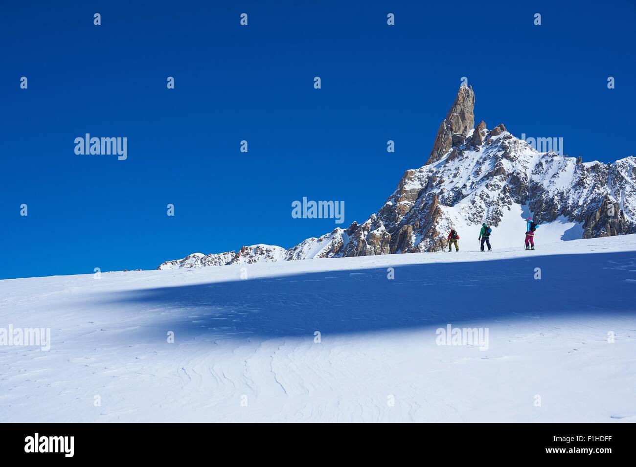 Distant view of three skiers moving up Mont Blanc massif, Graian Alps ...
